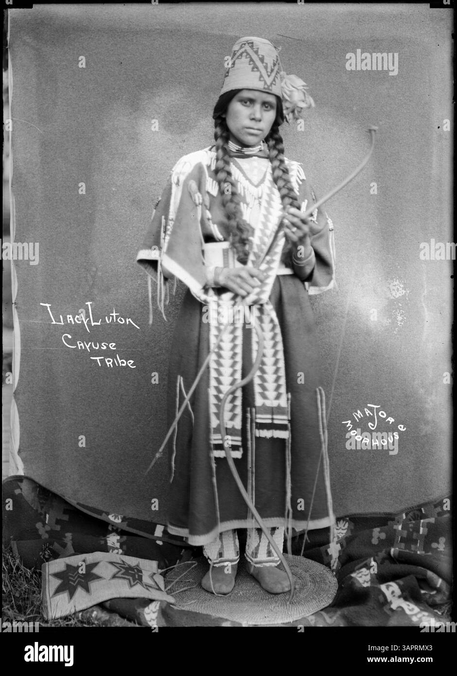 Lacy Luton, a Cayuse Indian, is seen in full regalia posing with a bow ...