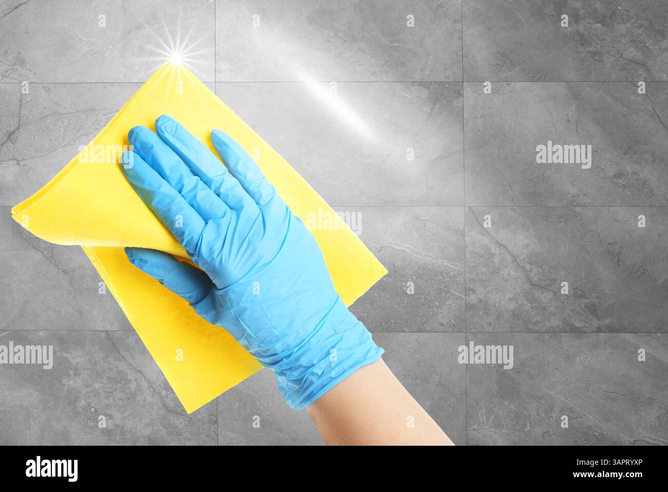 Cleaning service worker in rubber glove washing grey tiled wall with ...