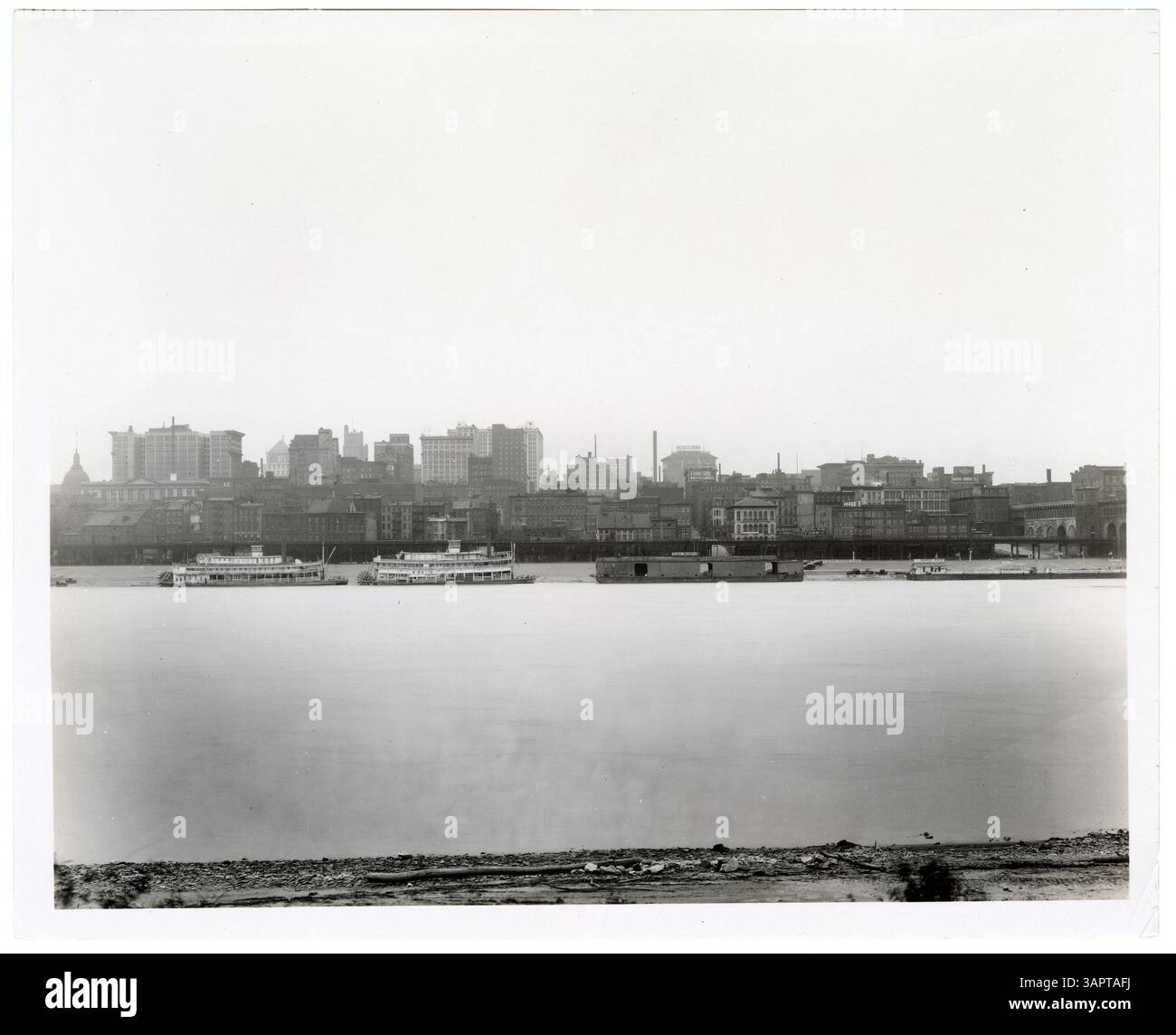 This black and white photograph captures three steamboats docked at the ...