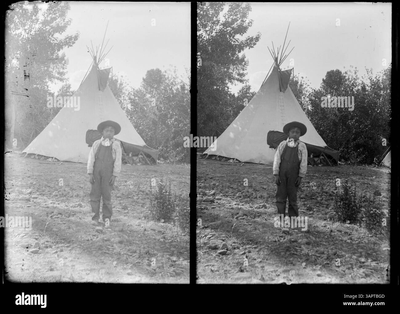 This stereo photograph shows a man standing in front of a tipi ...