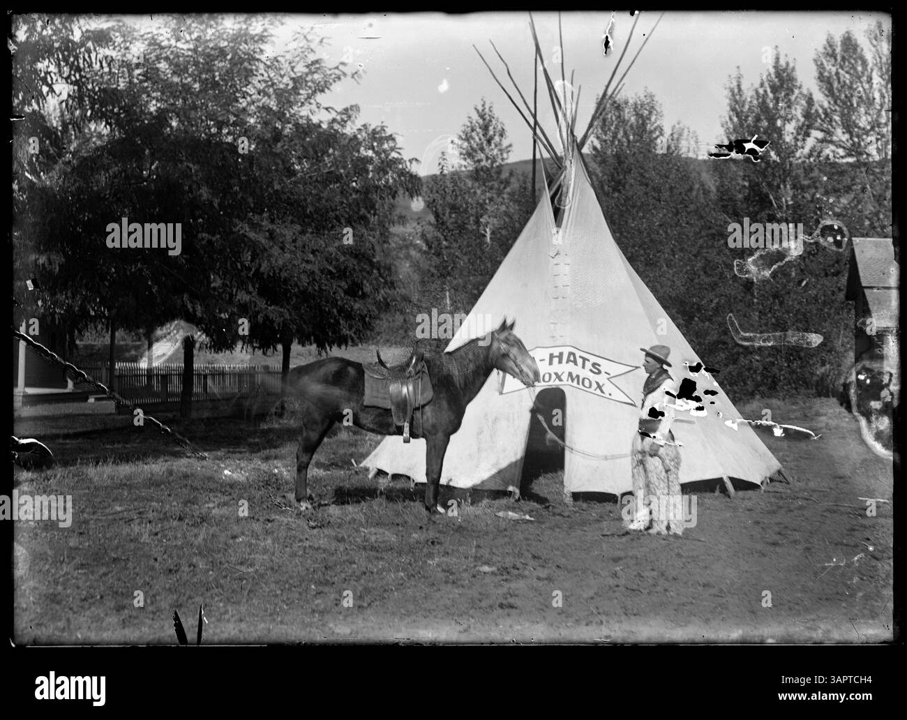 This photograph captures a cowboy, his horse, and a tipi, showcasing ...