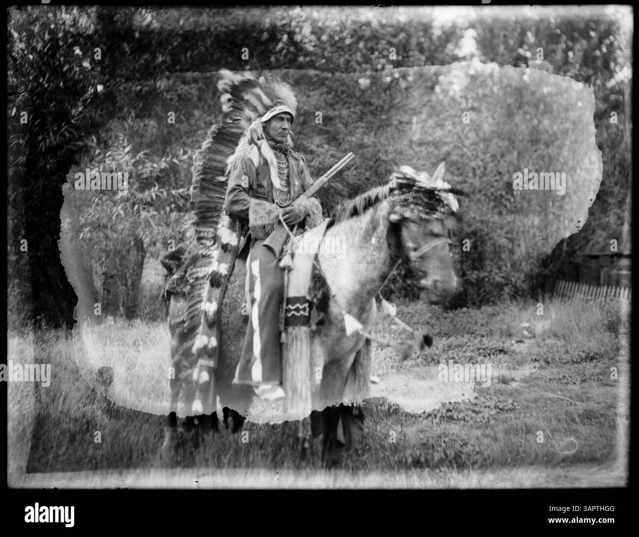 This photograph features a tribal man in full regalia riding a horse ...