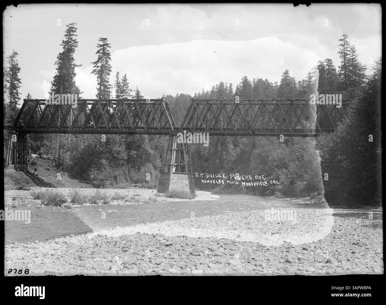 The photograph shows a Southern Pacific railroad bridge spanning a ...
