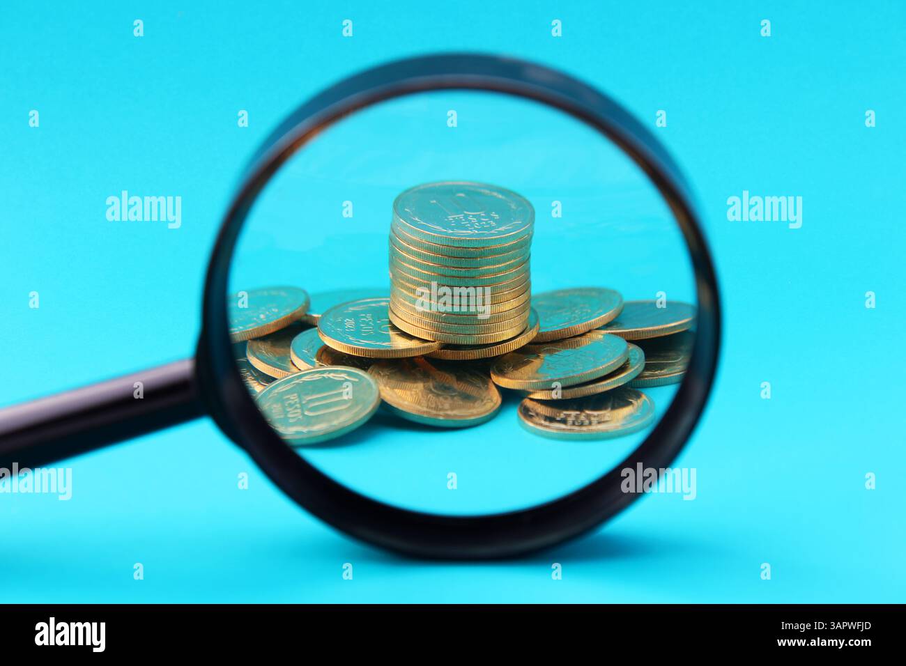 Magnifying glass expanding vision to find a group of coins Stock Photo ...