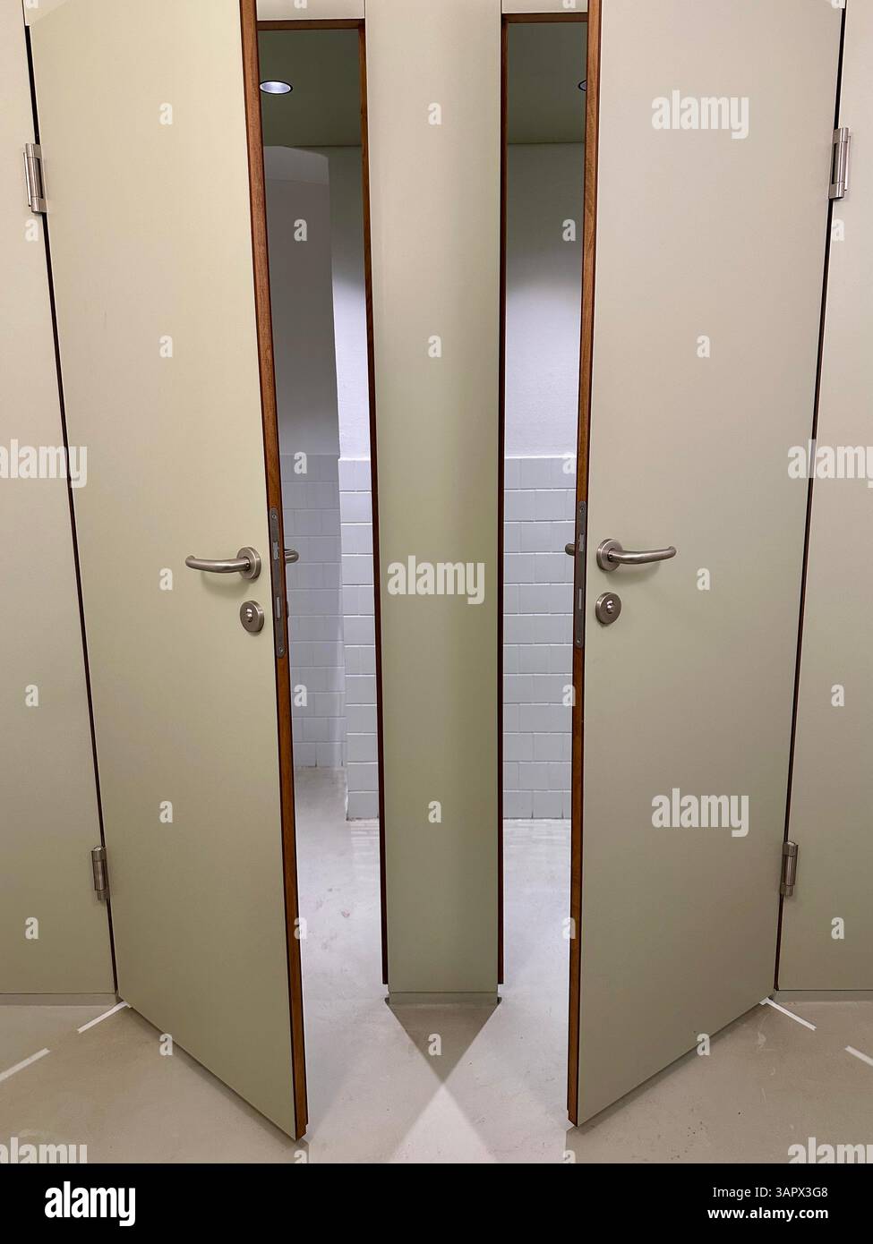 Two symmetrical open doors in a public bathroom Stock Photo - Alamy