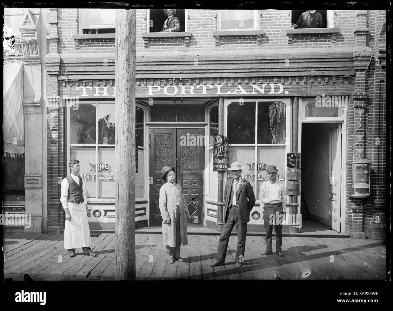 A photograph of the storefront 'The Portland' tavern with four men ...