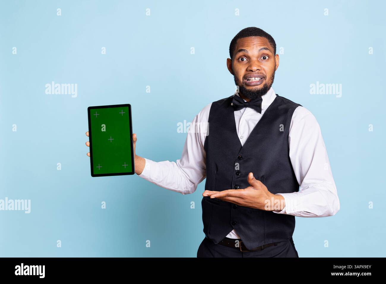 Bellman hotelier showing a tablet with green screen display in studio ...
