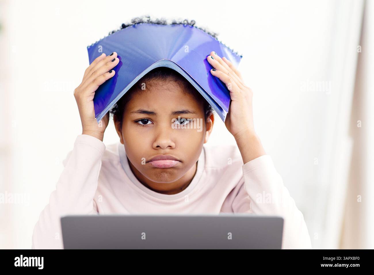 Sad Girl At Laptop Covering Head With Exercise-Book Sitting Indoors ...