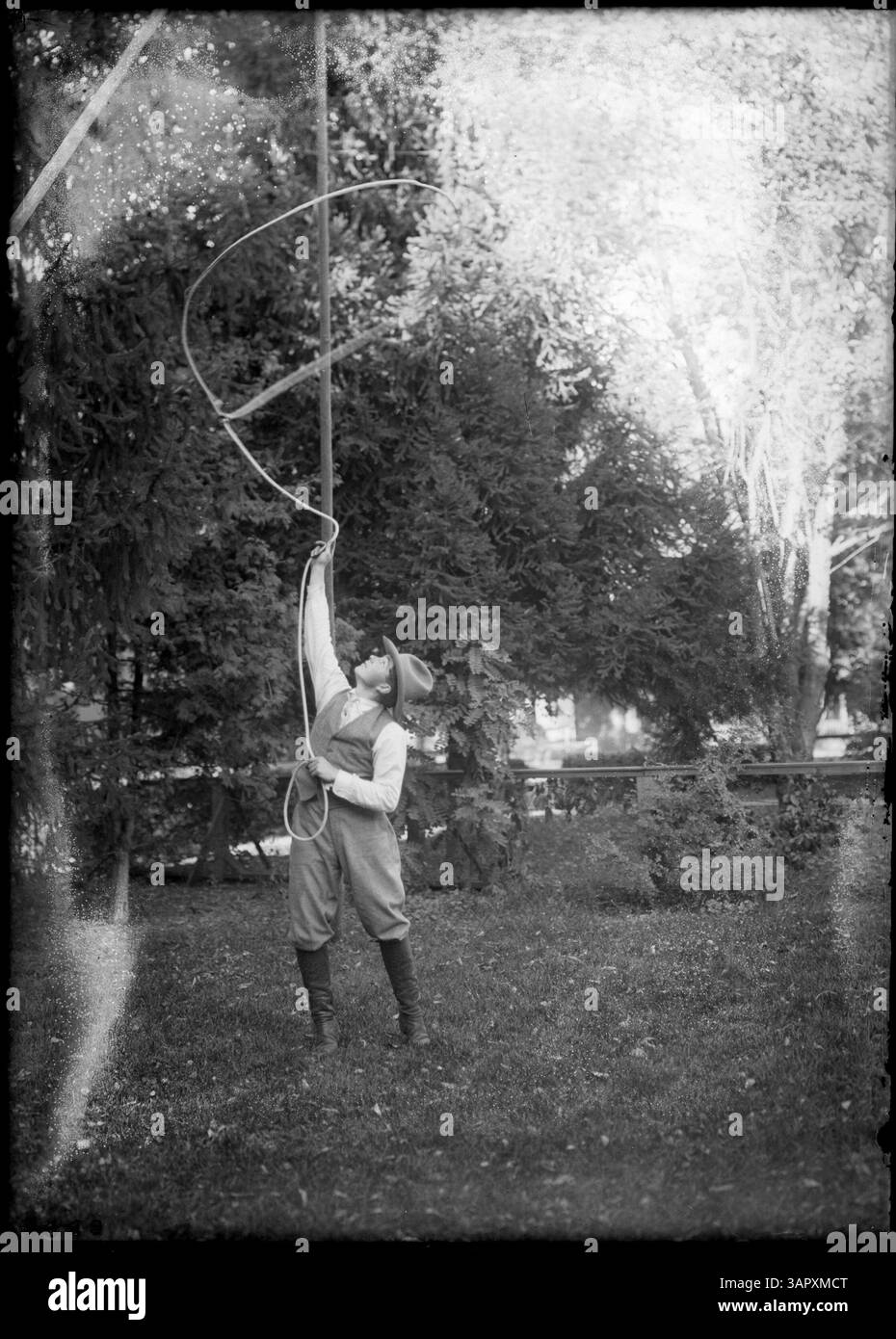 This image features L.E. McCoy performing trick roping, captured in a ...