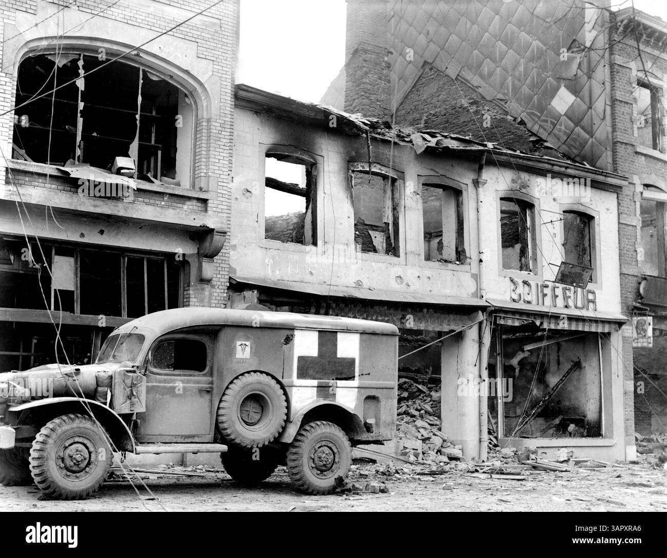 American ambulance waiting outside bombed building while a searcher ...