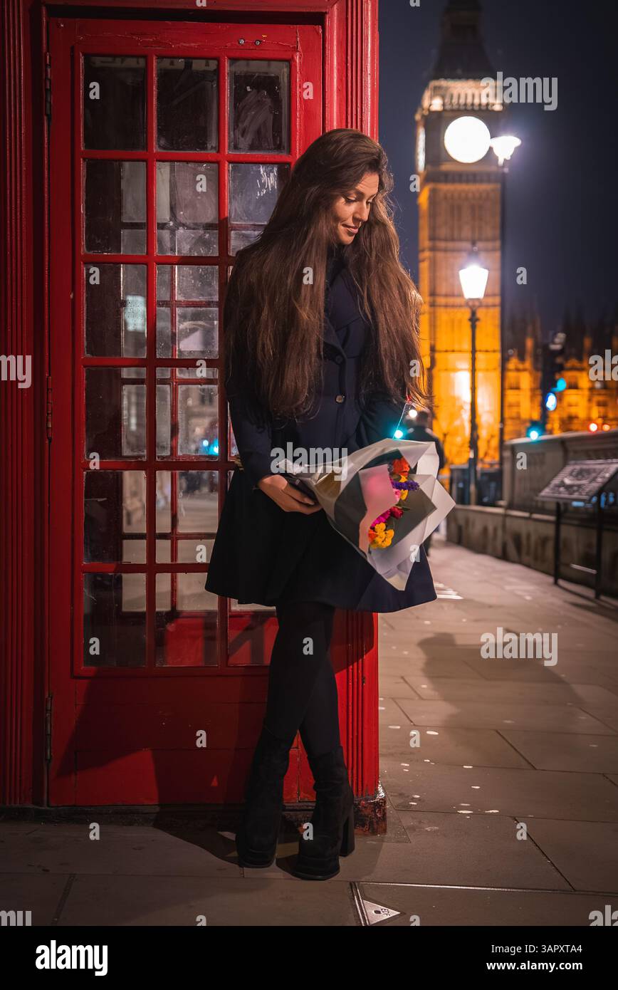 Woman with Flowers by Red Telephone Booth and Big Ben at Night Stock ...