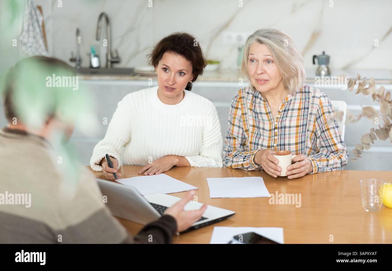 Mother and daughter considering offer from agent Stock Photo - Alamy