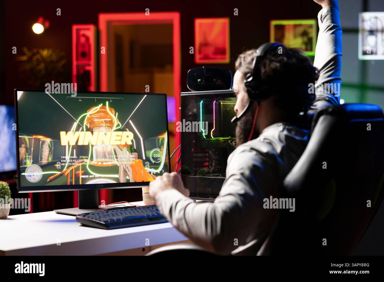 Happy pro gamer at home competing in intense multiplayer videogame ...