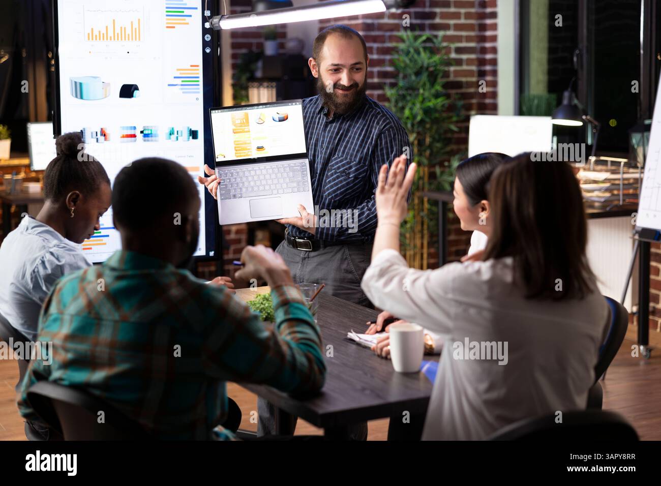 Caucasian businessman reviews brand strategy with startup team ...