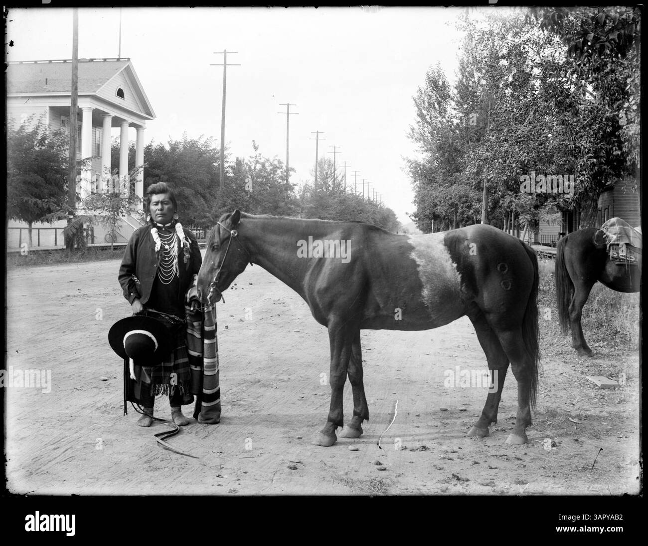 This photograph depicts a Native American man with a pony, showcasing a ...