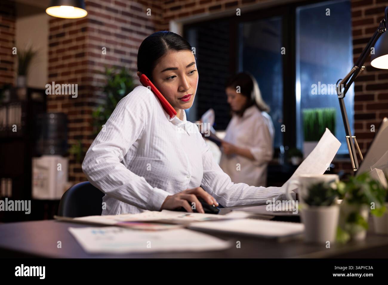 Busy woman juggles multiple tasks, having a phone call, holding a paper ...