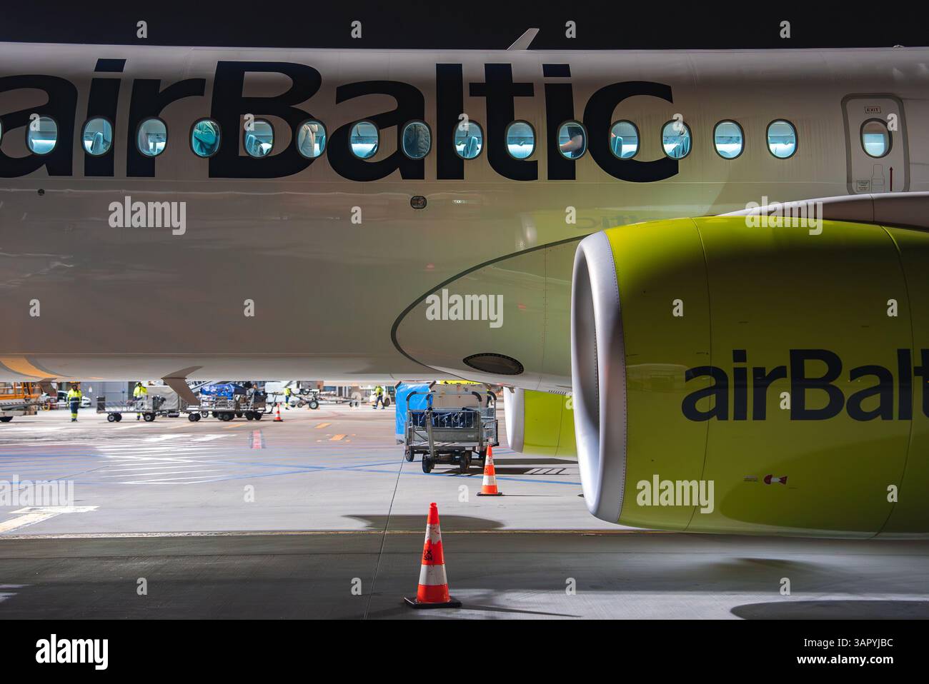 airBaltic Aircraft Parked on Tarmac at Night with Lime Green Engine ...