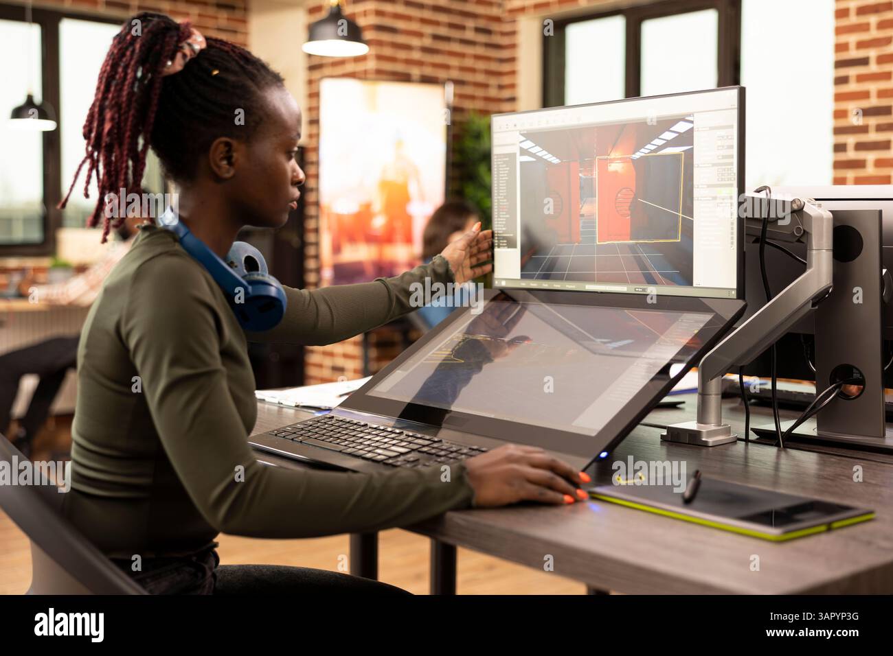 African American digital artist analyzing a creative project on desktop screen in a startup ...