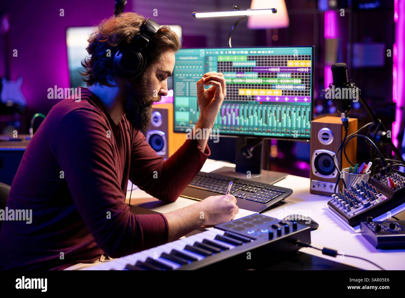 Composer songwriter taking notes to create a new song in his home ...