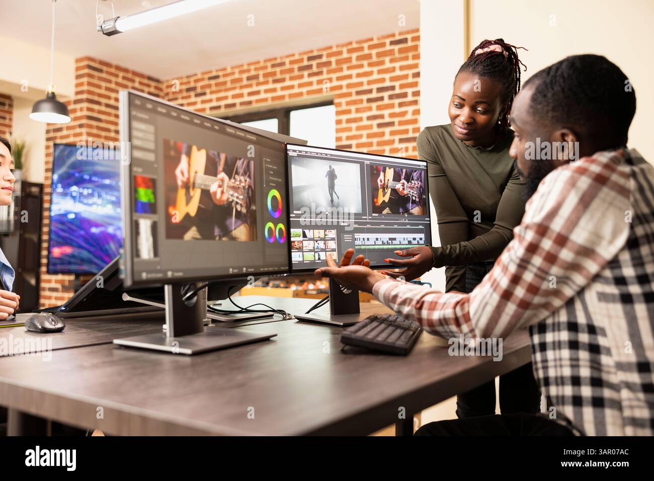 Skilled creative team using multi monitor setup to improve film frame ...