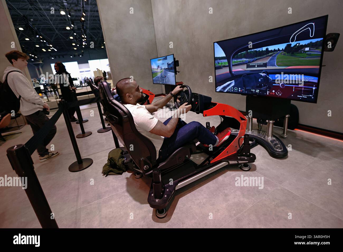 New York, United States. 16th Apr, 2025. People try out the race car ...