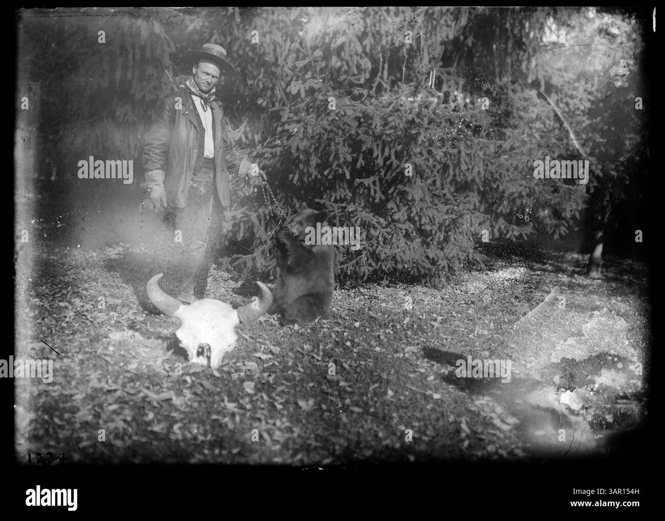 Photograph of a man with a tame, chained bear, capturing a moment of ...