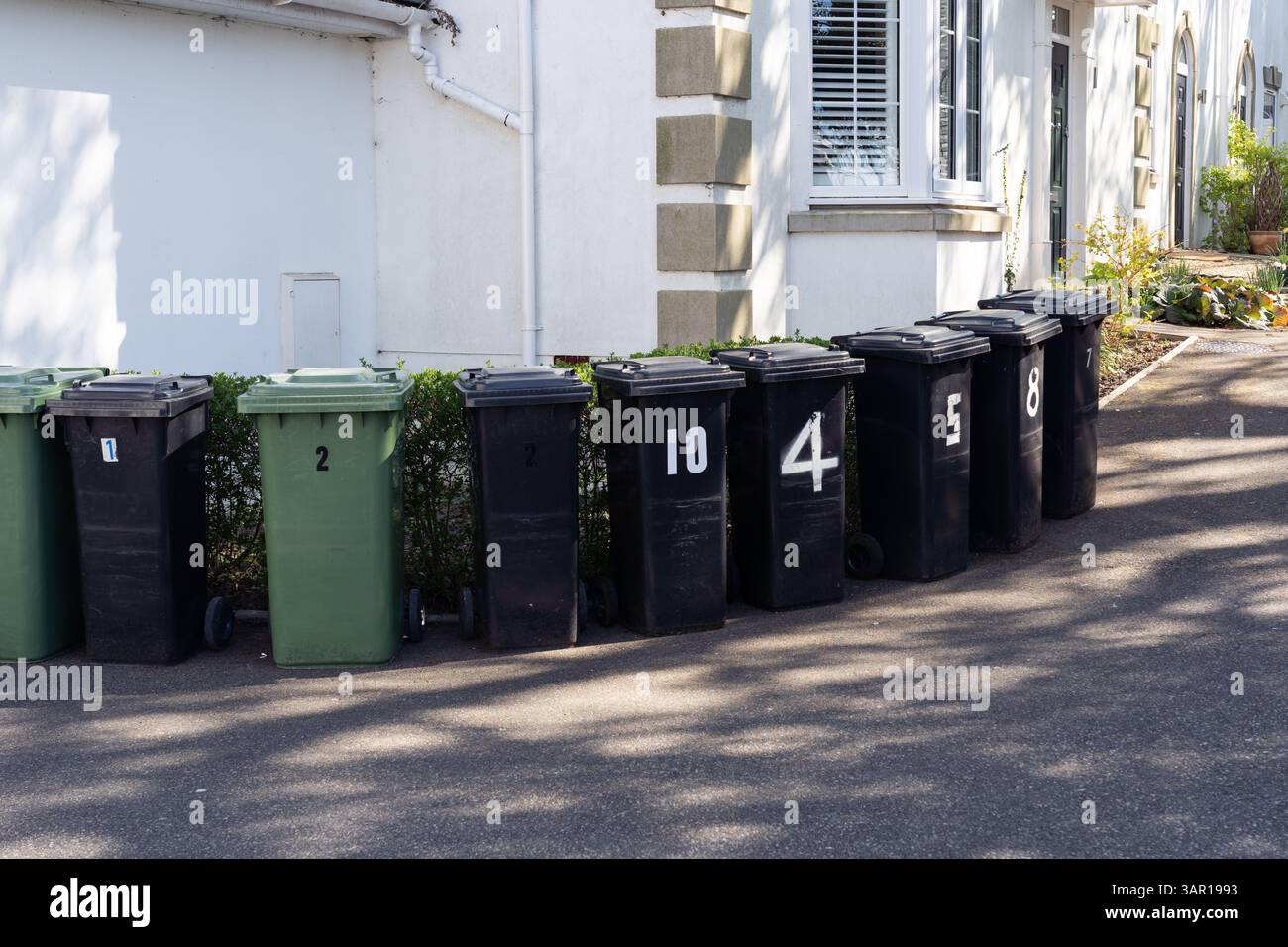 A line of recycling and household domestic waste wheelie bins in ...