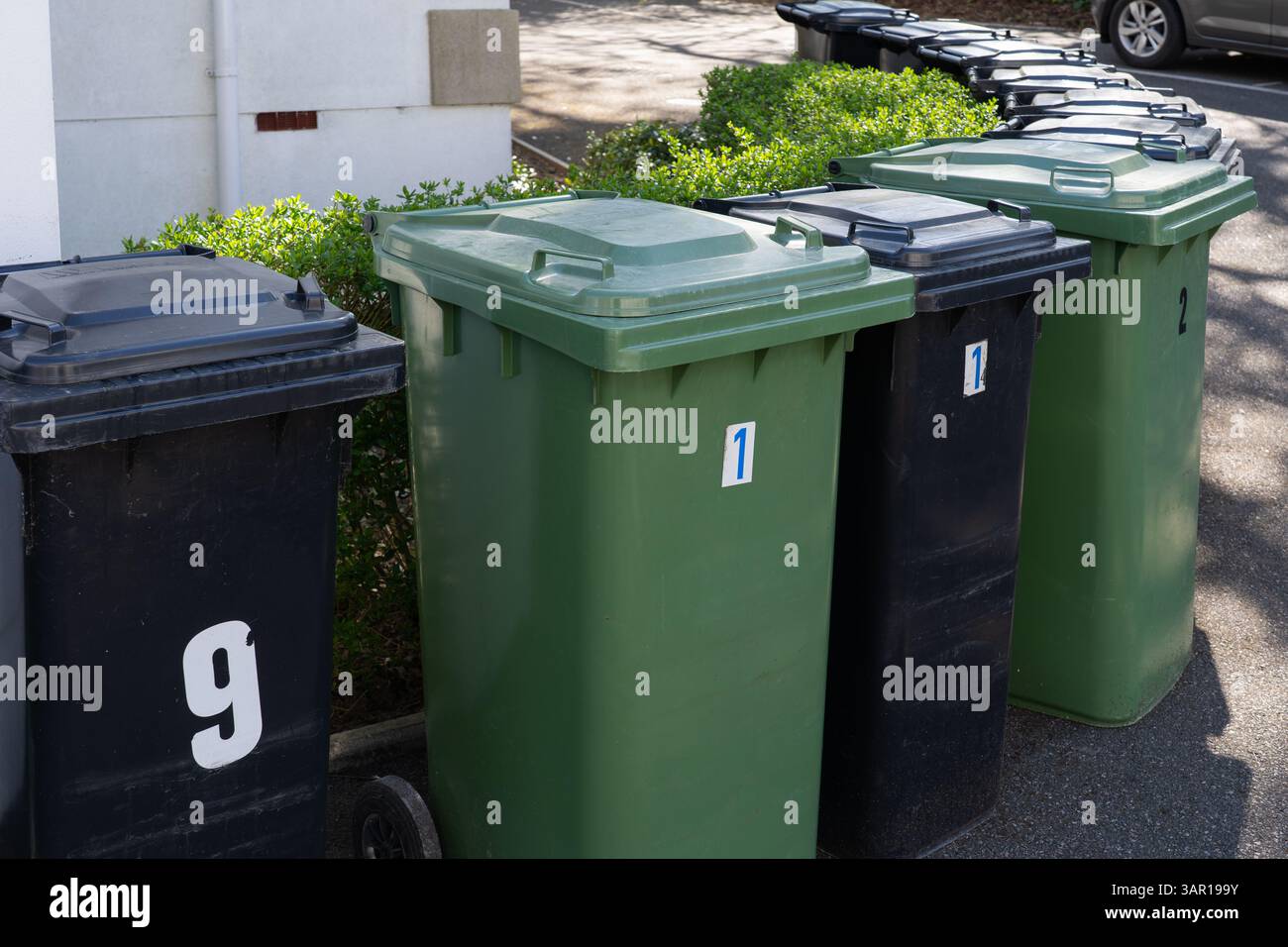 A line of recycling and household domestic waste wheelie bins in ...