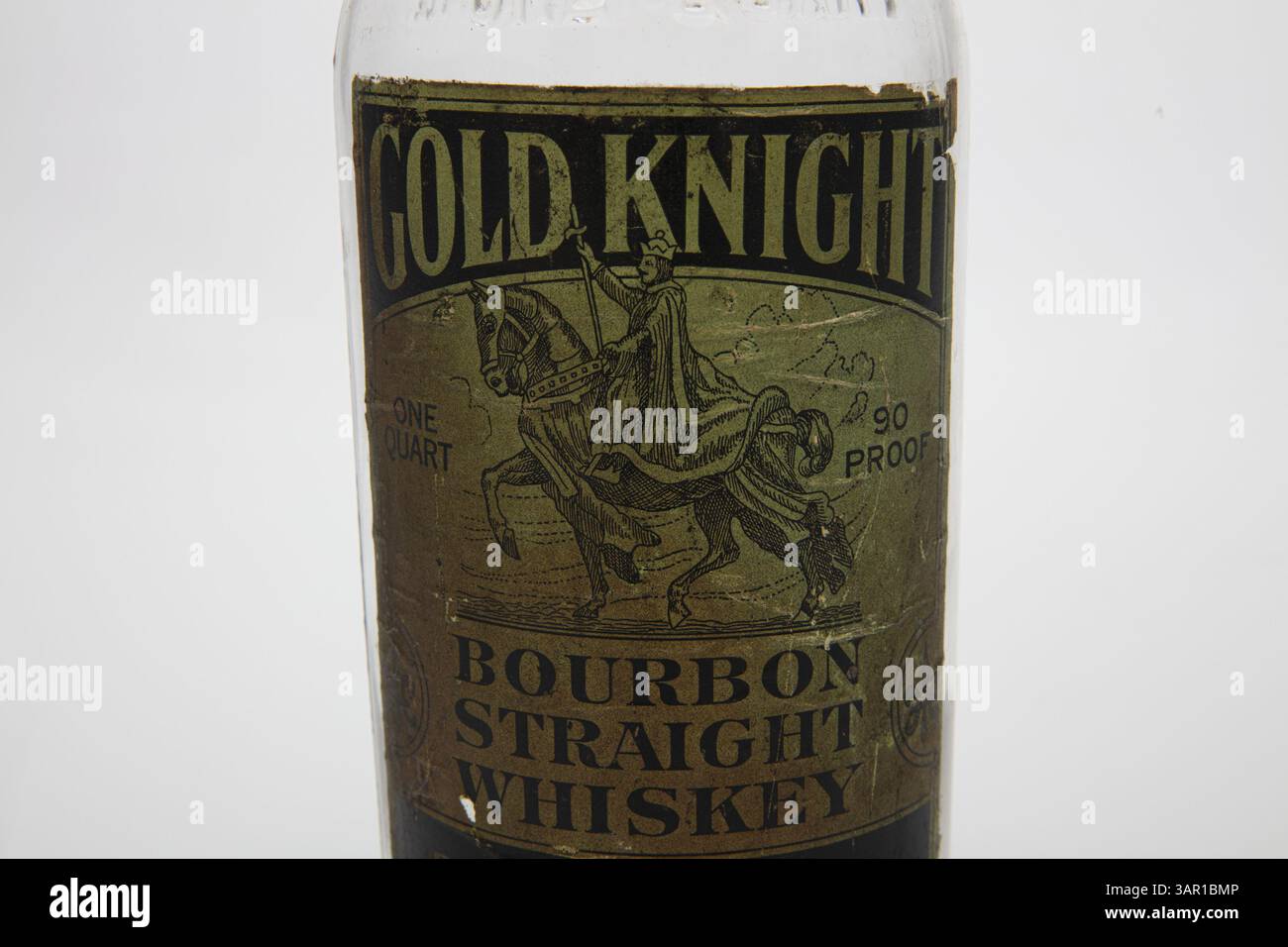 A clear glass bottle produced for Gold Knight whiskey by Brown-Owen ...