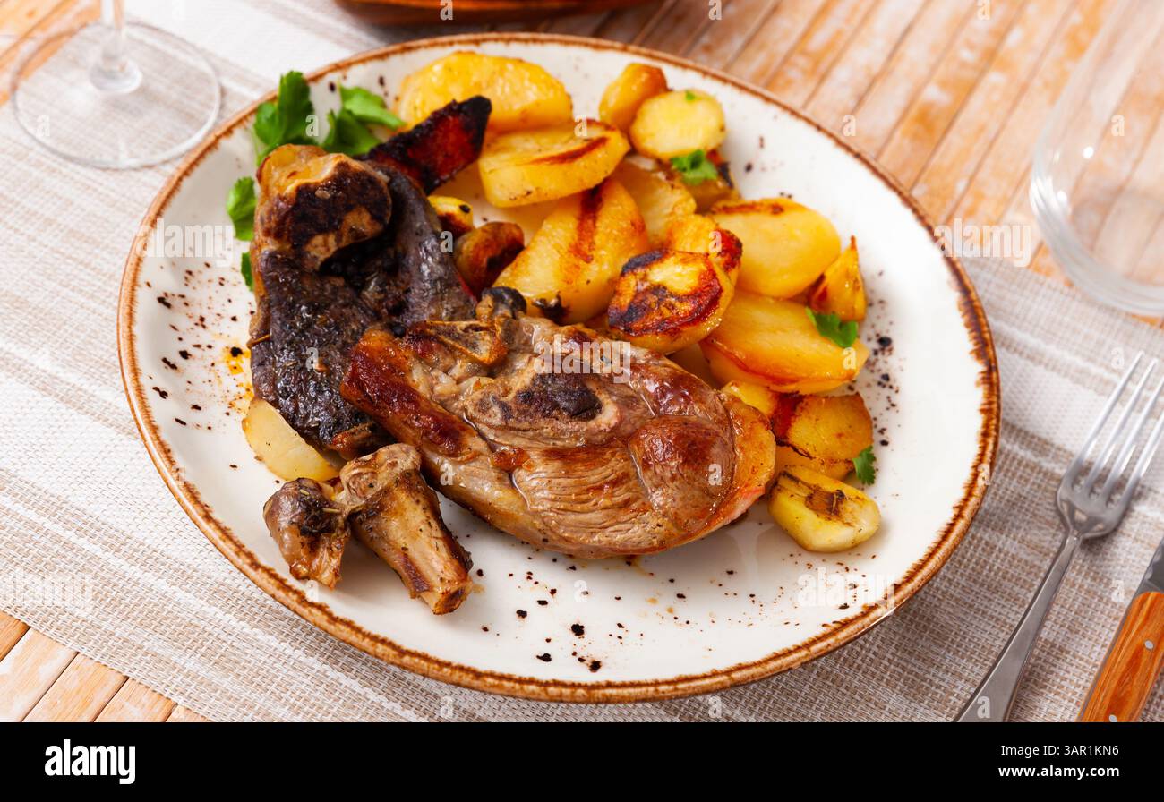 Roasted leg of lamb served with potatoes Stock Photo - Alamy
