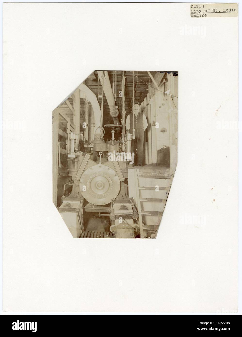 This black-and-white photograph shows a man standing next to the port ...