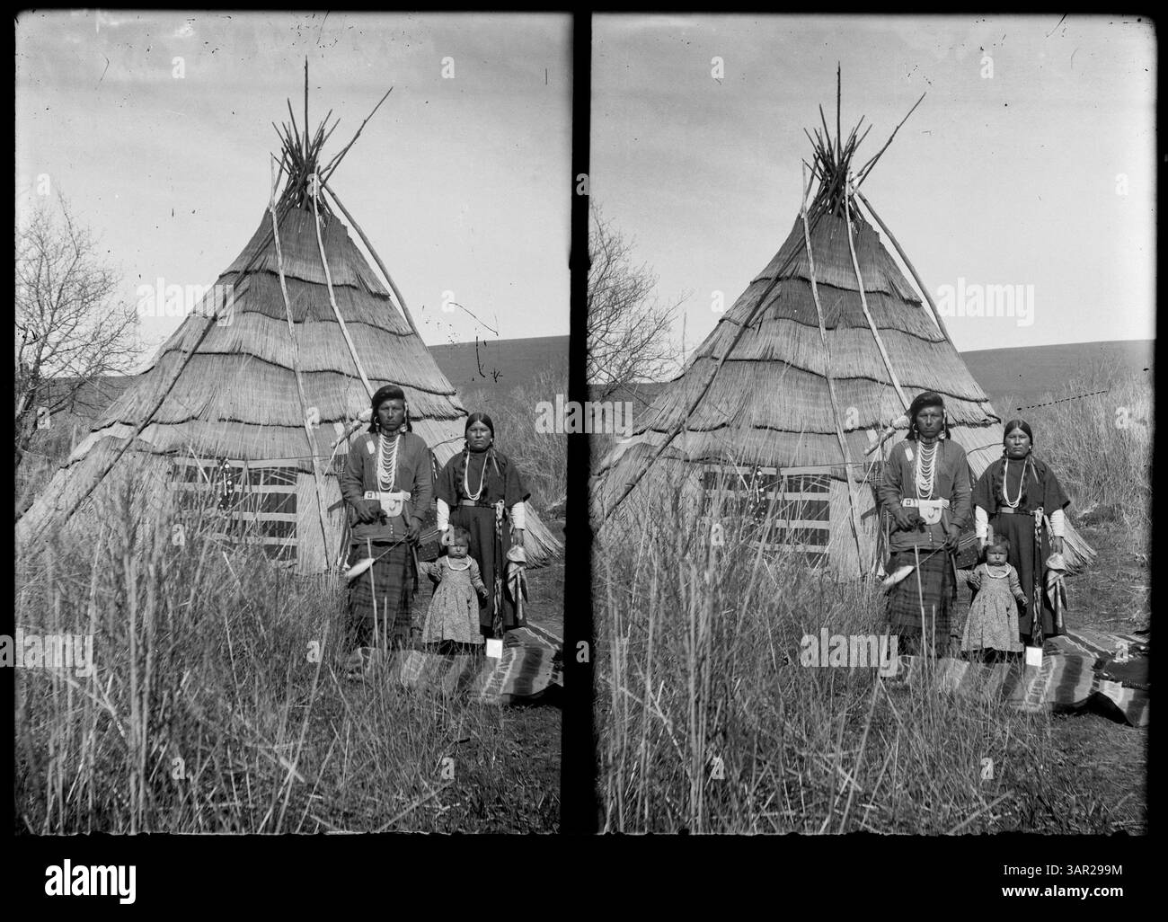 A stereo photograph depicting a man, woman, and child standing in front ...