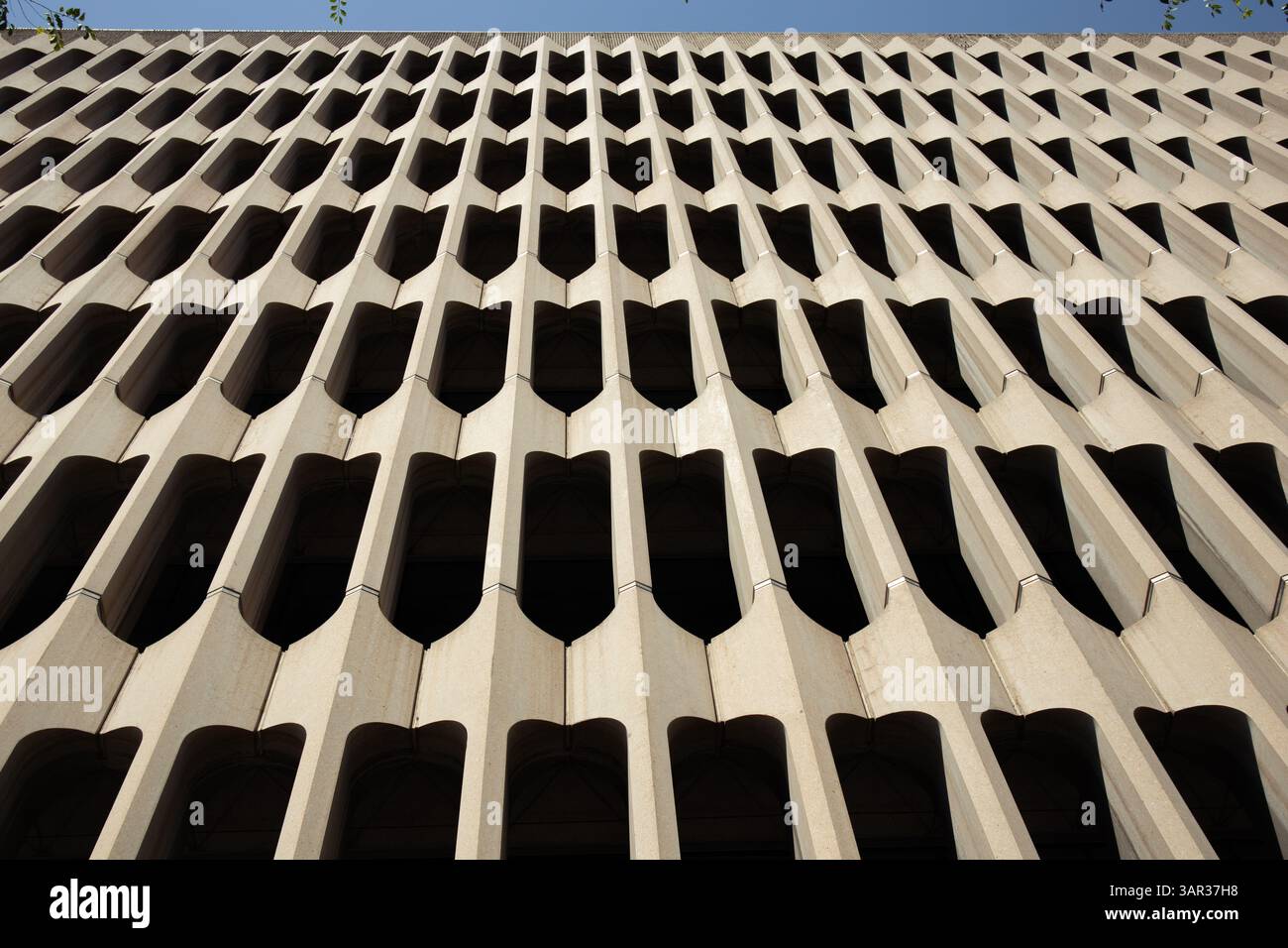 The facade of a modernist building features a repeating pattern of ...