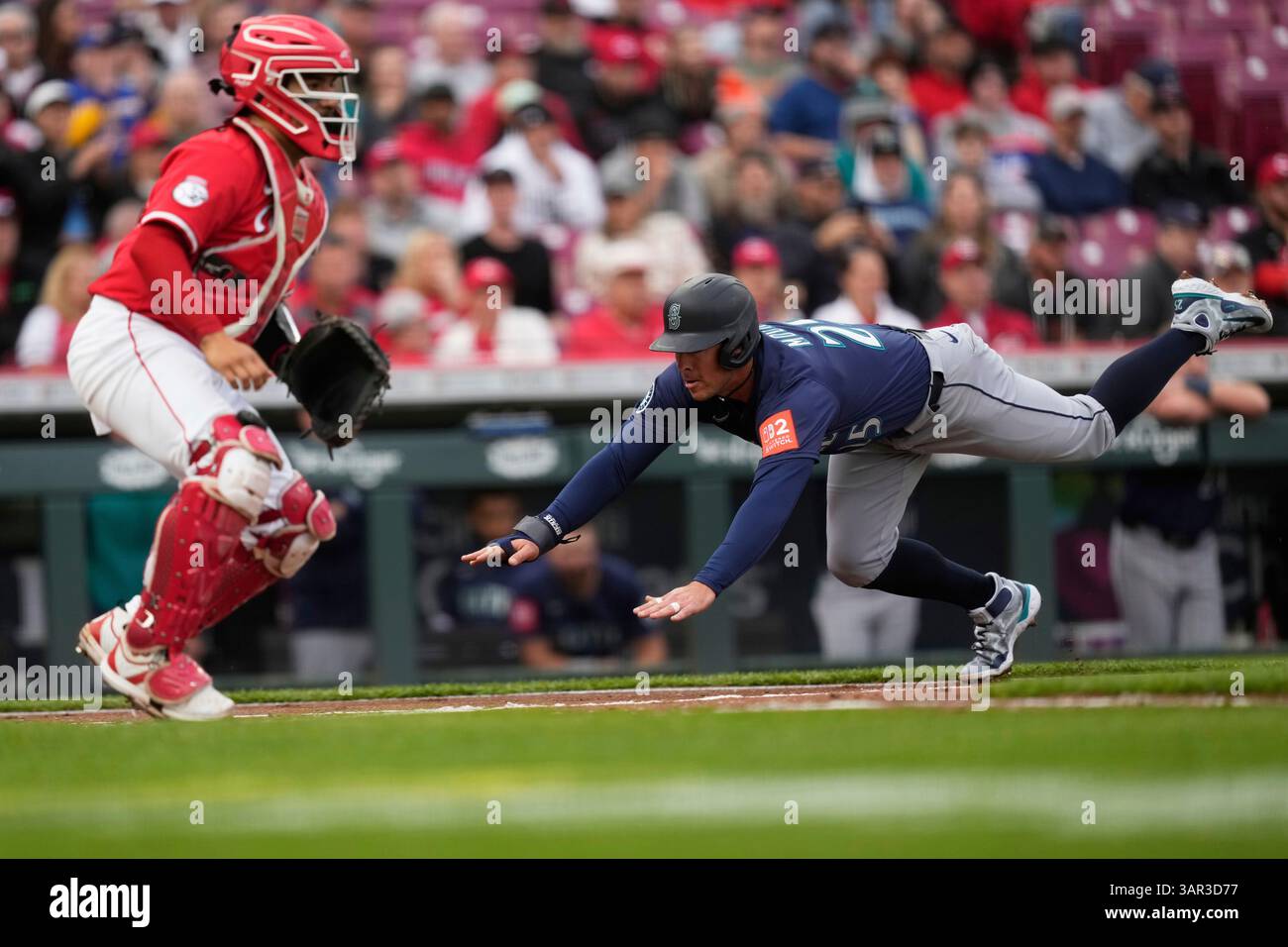 Seattle Mariners' Dylan Moore dives into home plate to score on a ...
