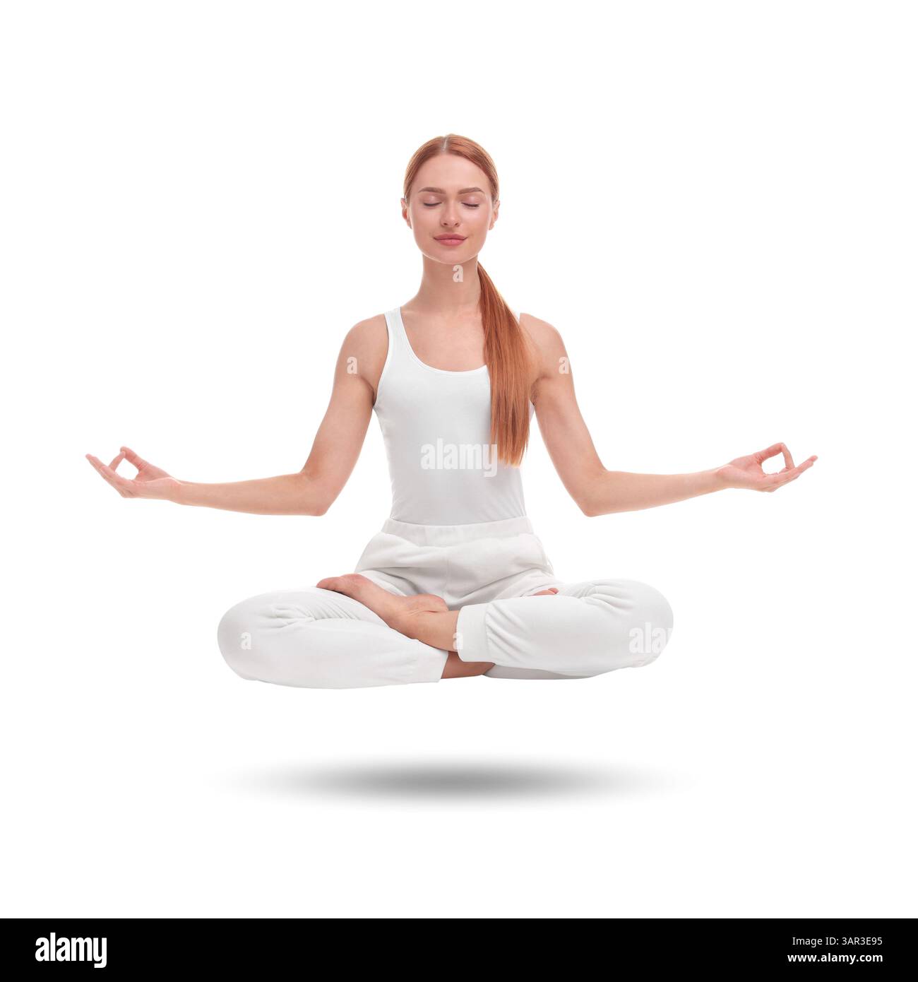 Young woman levitating during meditation on white background ...