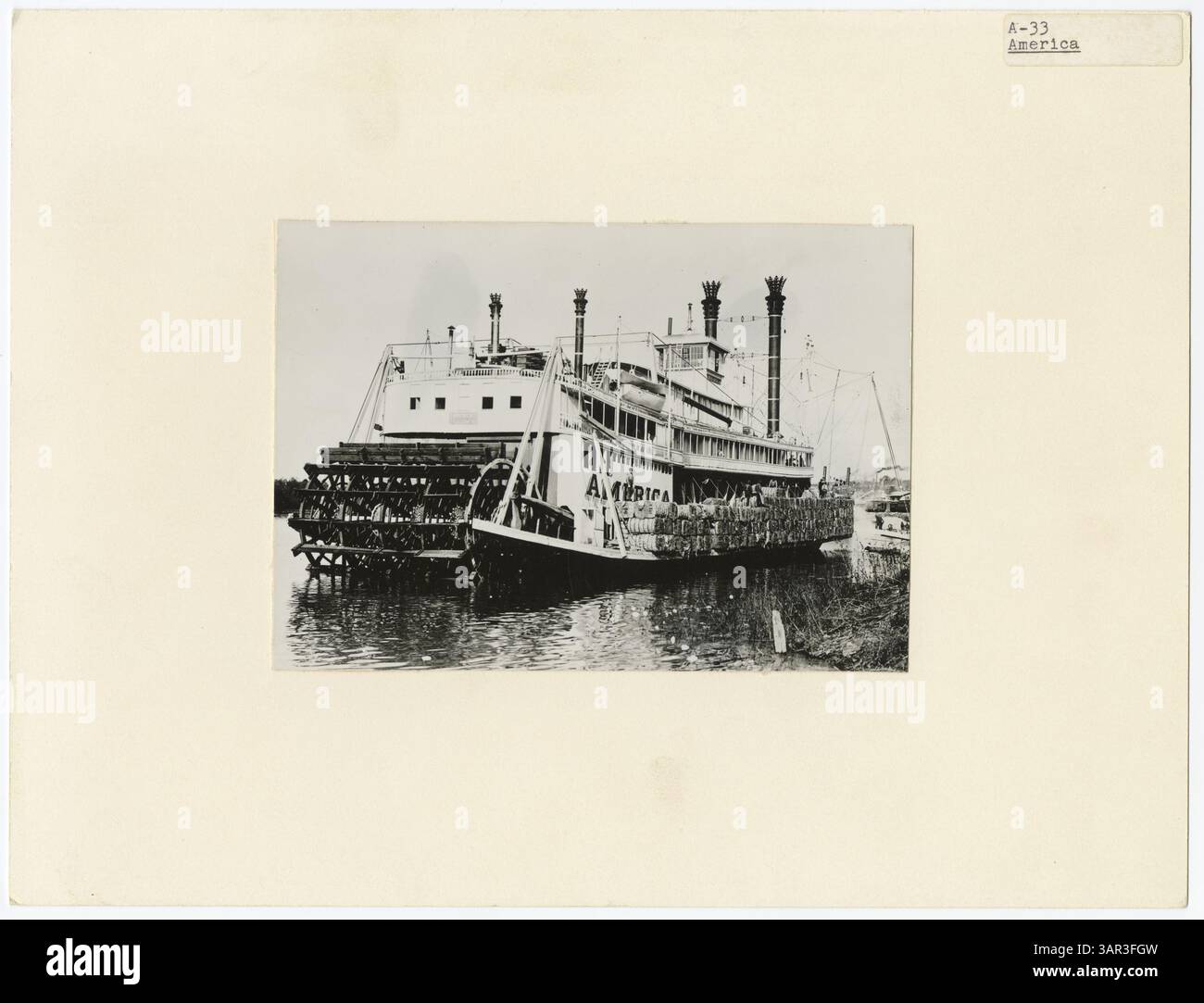 Photograph showing the steamer America docked on the river with cotton ...