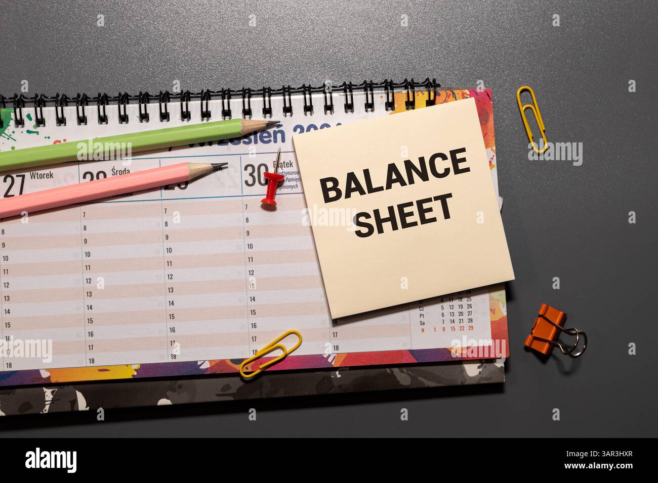 BALANCE SHEET text on a notebook with clipboard and calculator on white ...