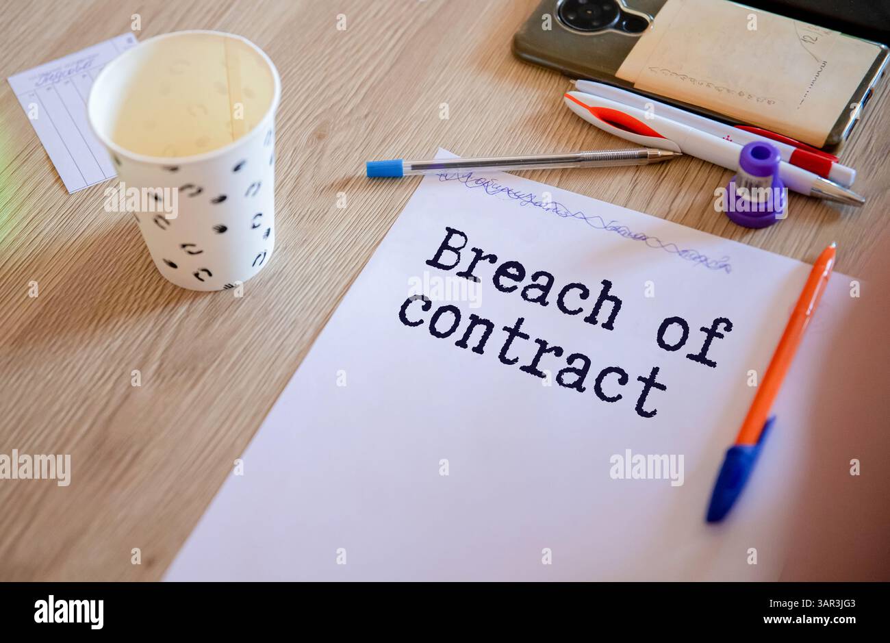 BREACH OF CONTRACT. text in notepad next to glasses on white background ...