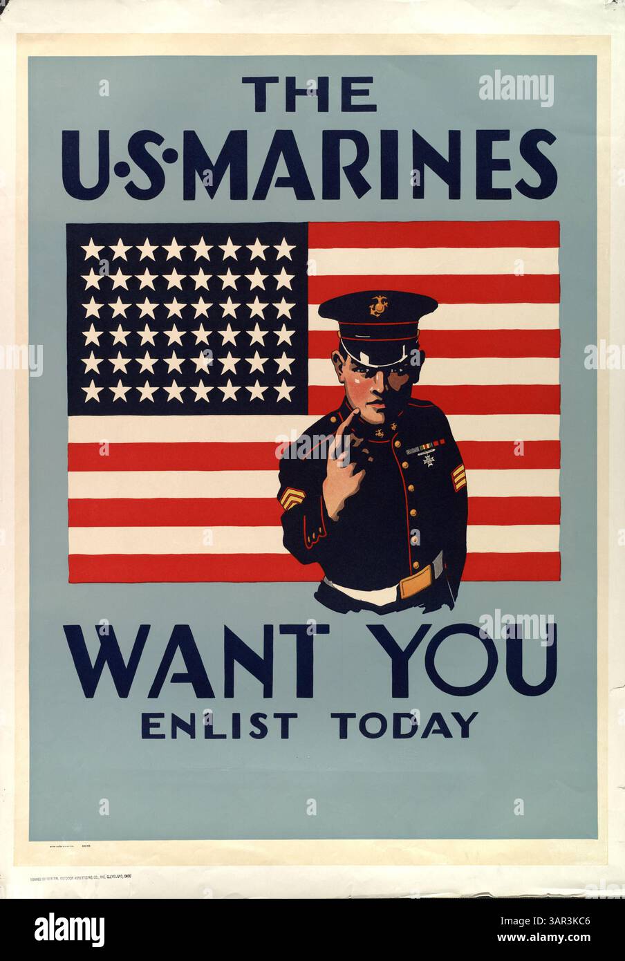 A Marine Sergeant gestures to the viewer in front of an American flag ...