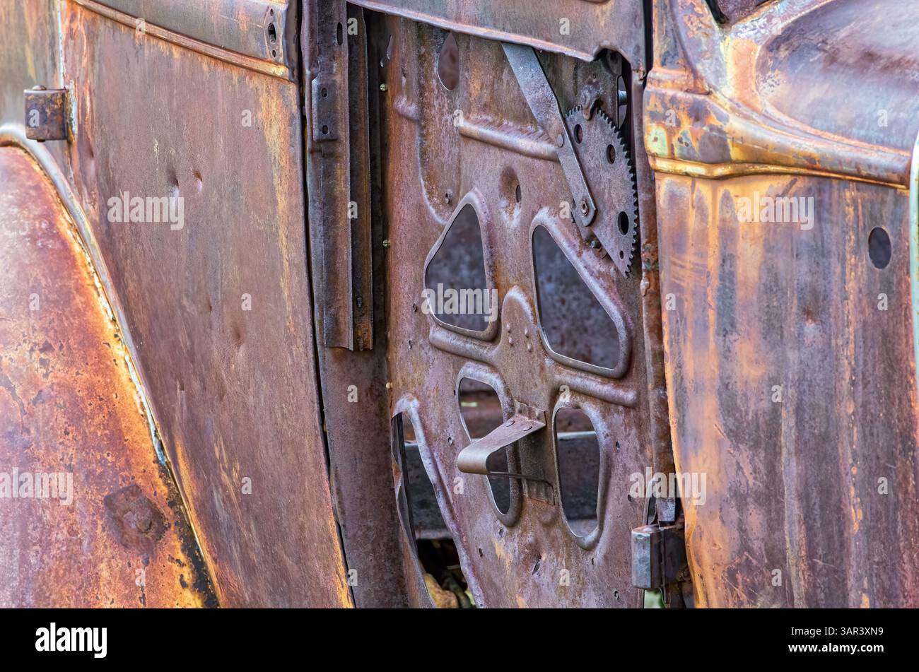 Close-up of a rusted antique car door showing exposed internal gears ...