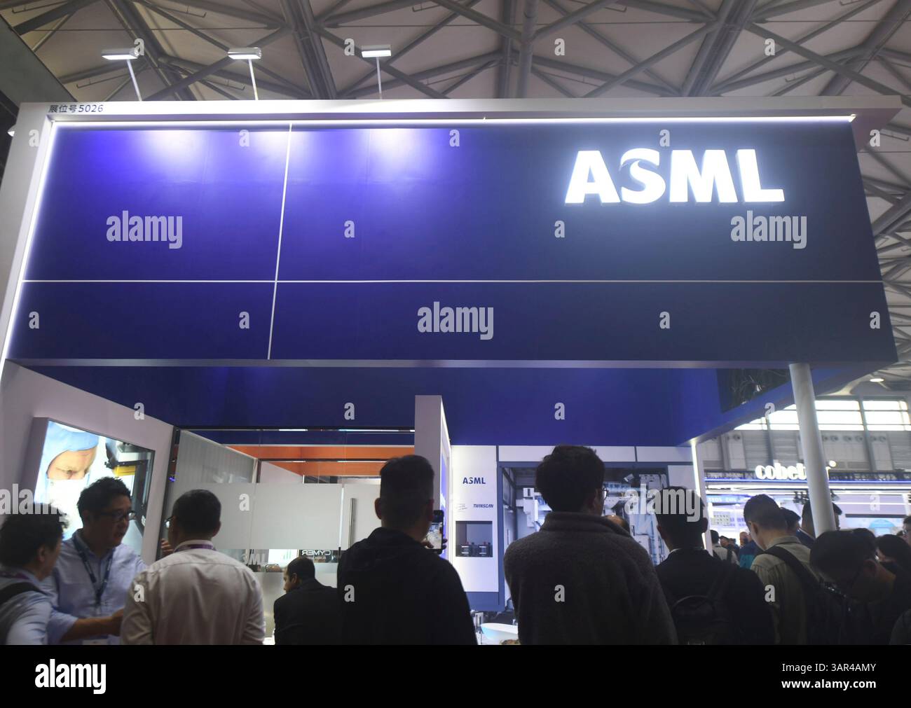 People visit the booth of ASML, a maker of semiconductor manufacturing ...
