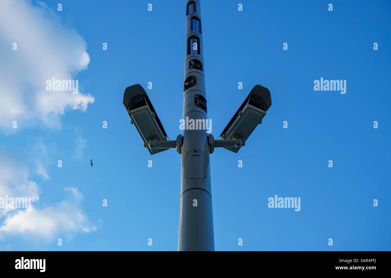 Security cameras on a tall streetlight against blue sky at Museum ...