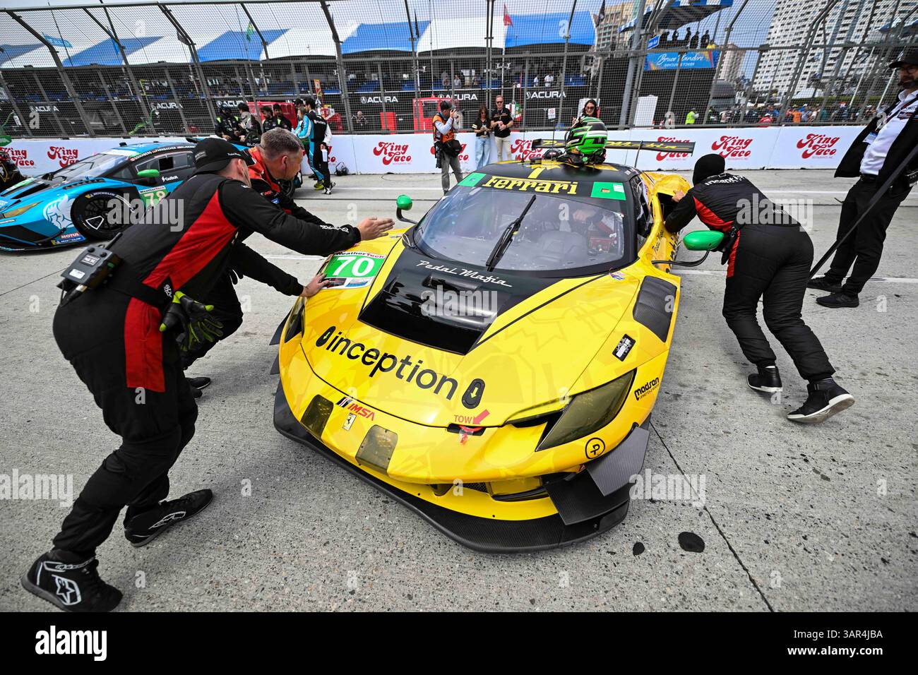 Members from the Inception Racing team push their Ferrari from the IMSA ...