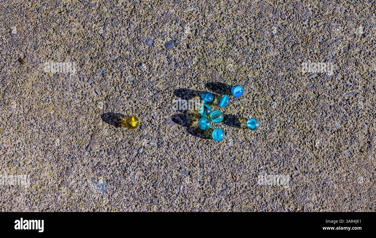 A few marbles are scattered on the ground, with one of them being ...
