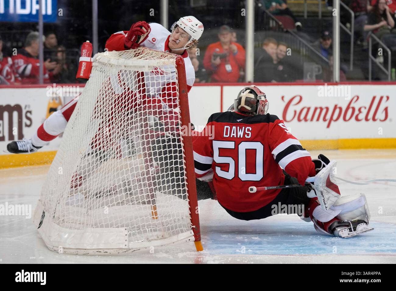 Detroit Red Wings' Simon Edvinsson, left, hits the goal while trying to ...