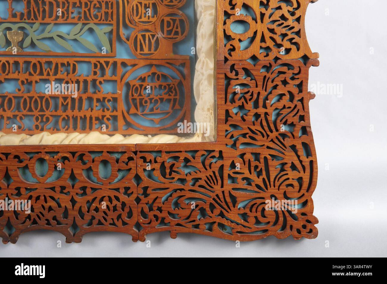 This shadow box, created by Leon Zonga in 1931, features a carved scrollwork display honoring ...