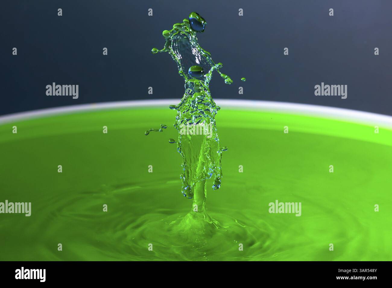 Green drop shoots up dynamically and forms a towering shape in a calm ...