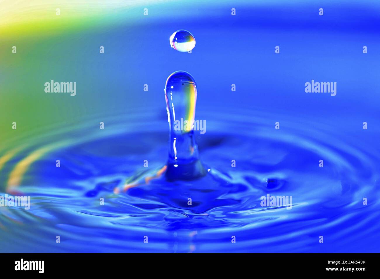 A blue drop hits the water surface and creates a vivid colour gradient ...