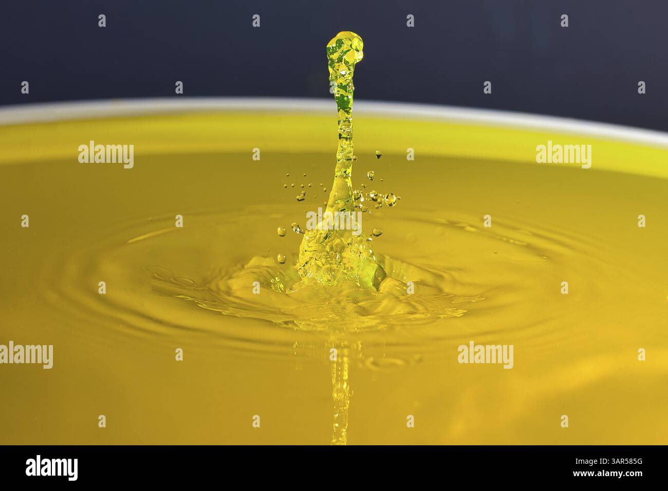 Single yellow water drop splashes on yellow water surface, water drop ...