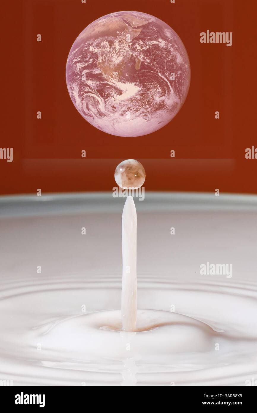 Two drops simulate a planet and a moon over a white liquid in front of ...